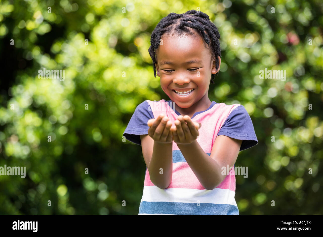 Smiling boy looking at his hands Stock Photo - Alamy