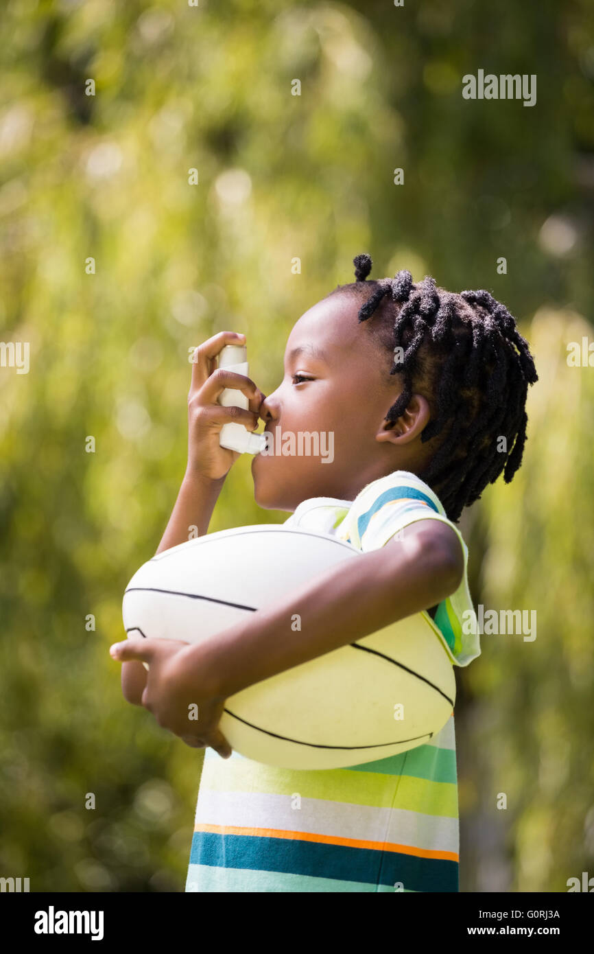 Profile view of a kid using an asthma inhaler Stock Photo - Alamy