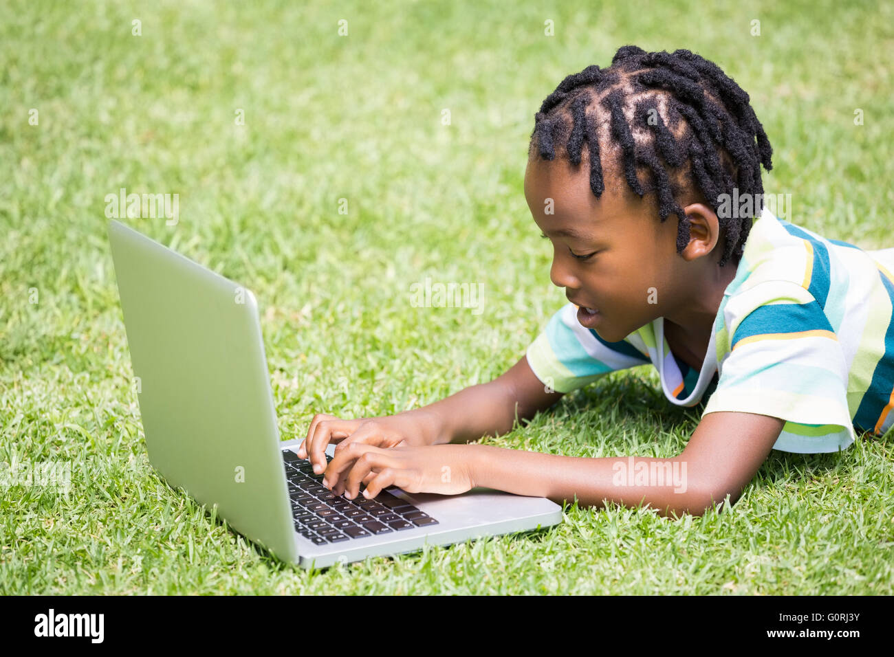 A kid lying and playing with his laptop Stock Photo - Alamy