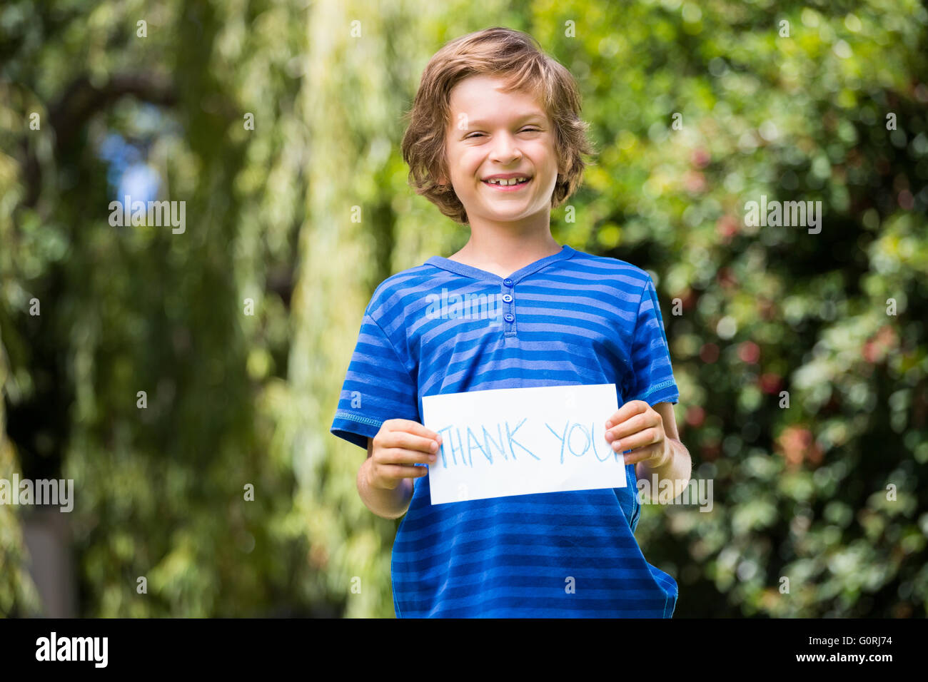 Cute boy smiling and holding a message Stock Photo - Alamy