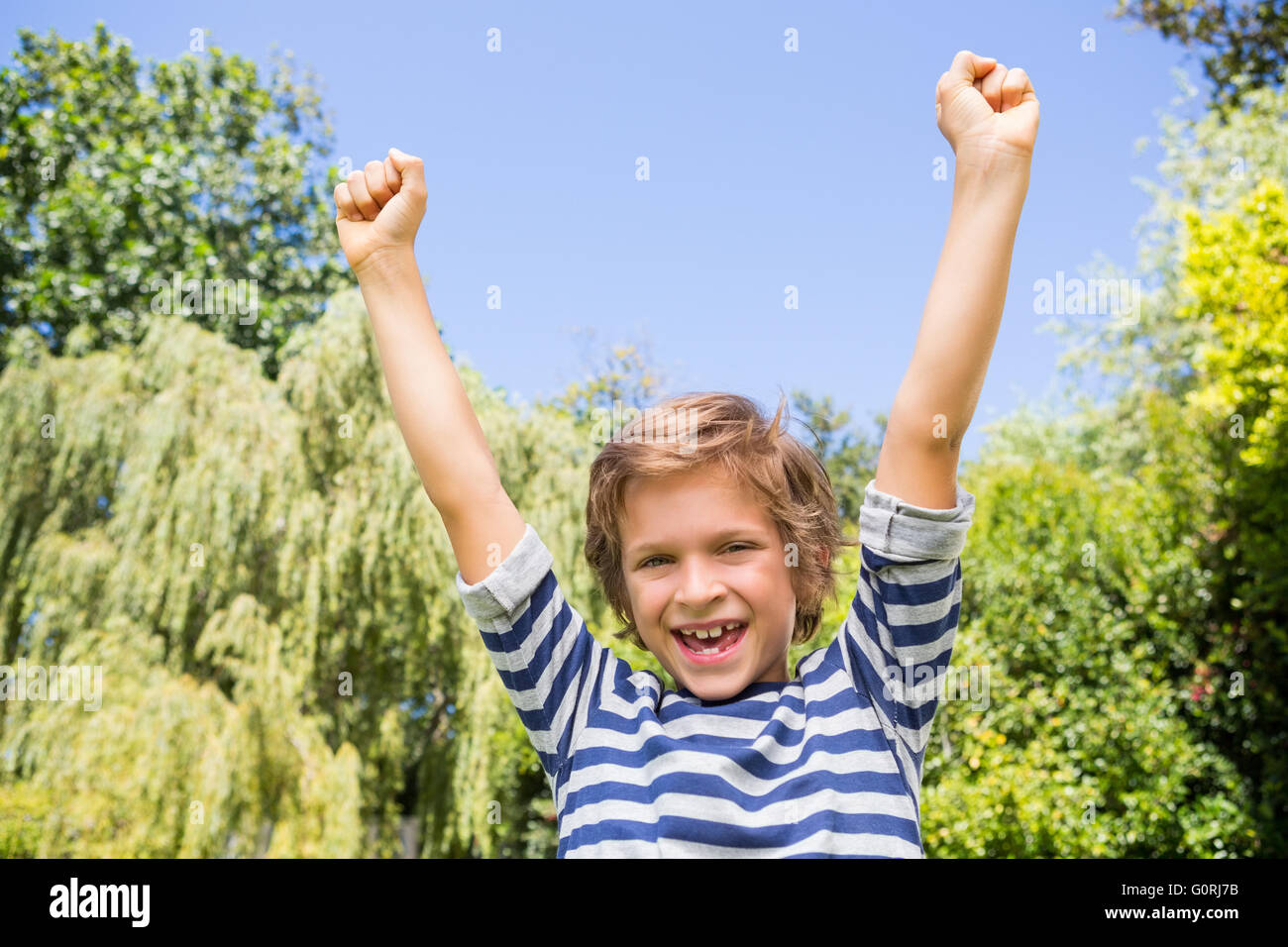 Portrait of happy boy raising arms Stock Photo - Alamy
