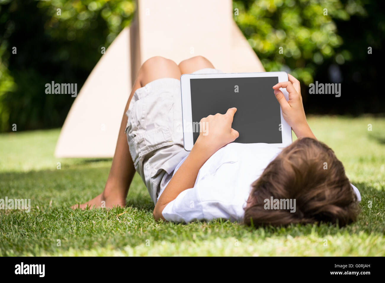 A kid is lying with a tablet computer Stock Photo - Alamy