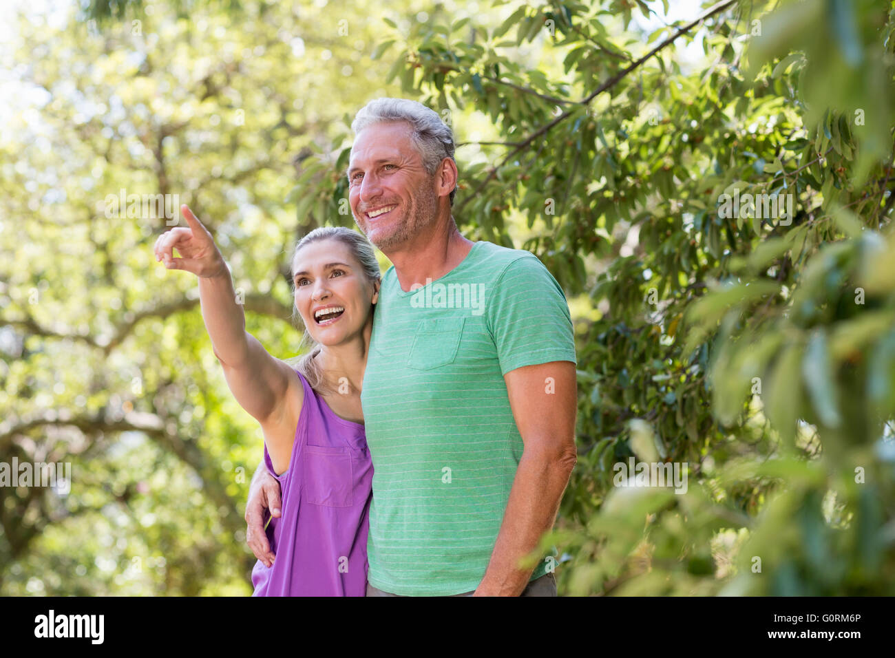 Couple smiling and pointing Stock Photo - Alamy