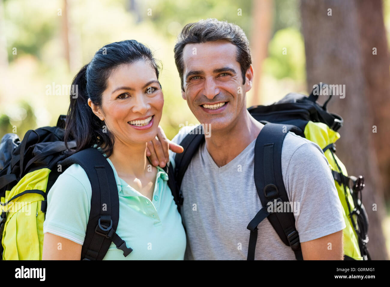 Couple smiling and posing with backpacks Stock Photo - Alamy