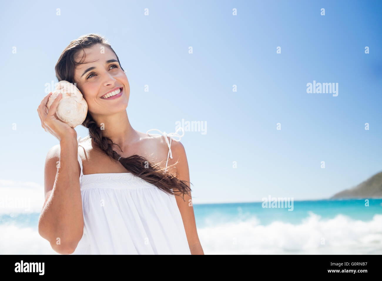 Portrait of smiling woman listening shellfish Stock Photo - Alamy