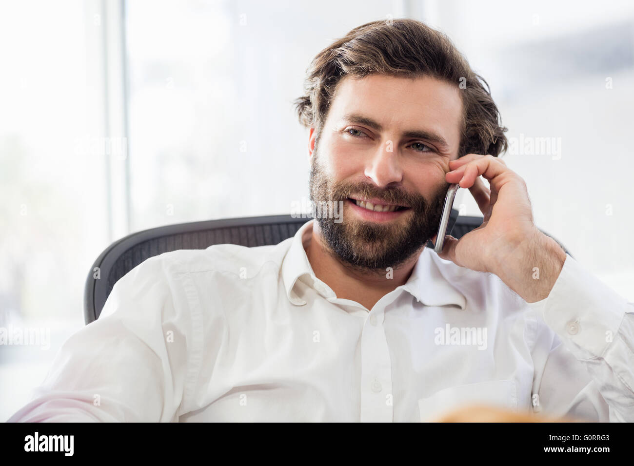 A smiling man passing a call Stock Photo - Alamy