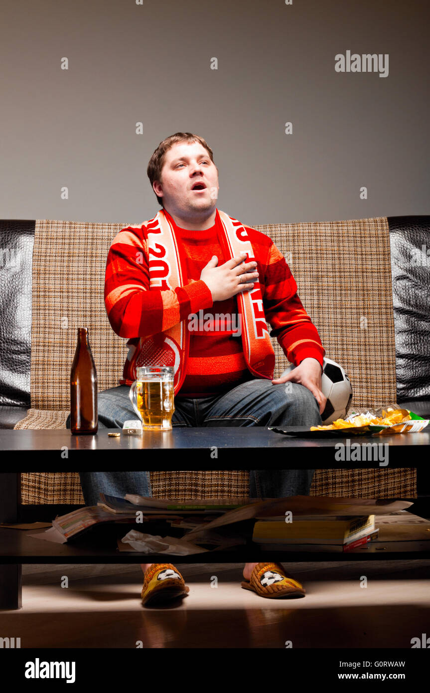soccer fan on sofa Stock Photo - Alamy
