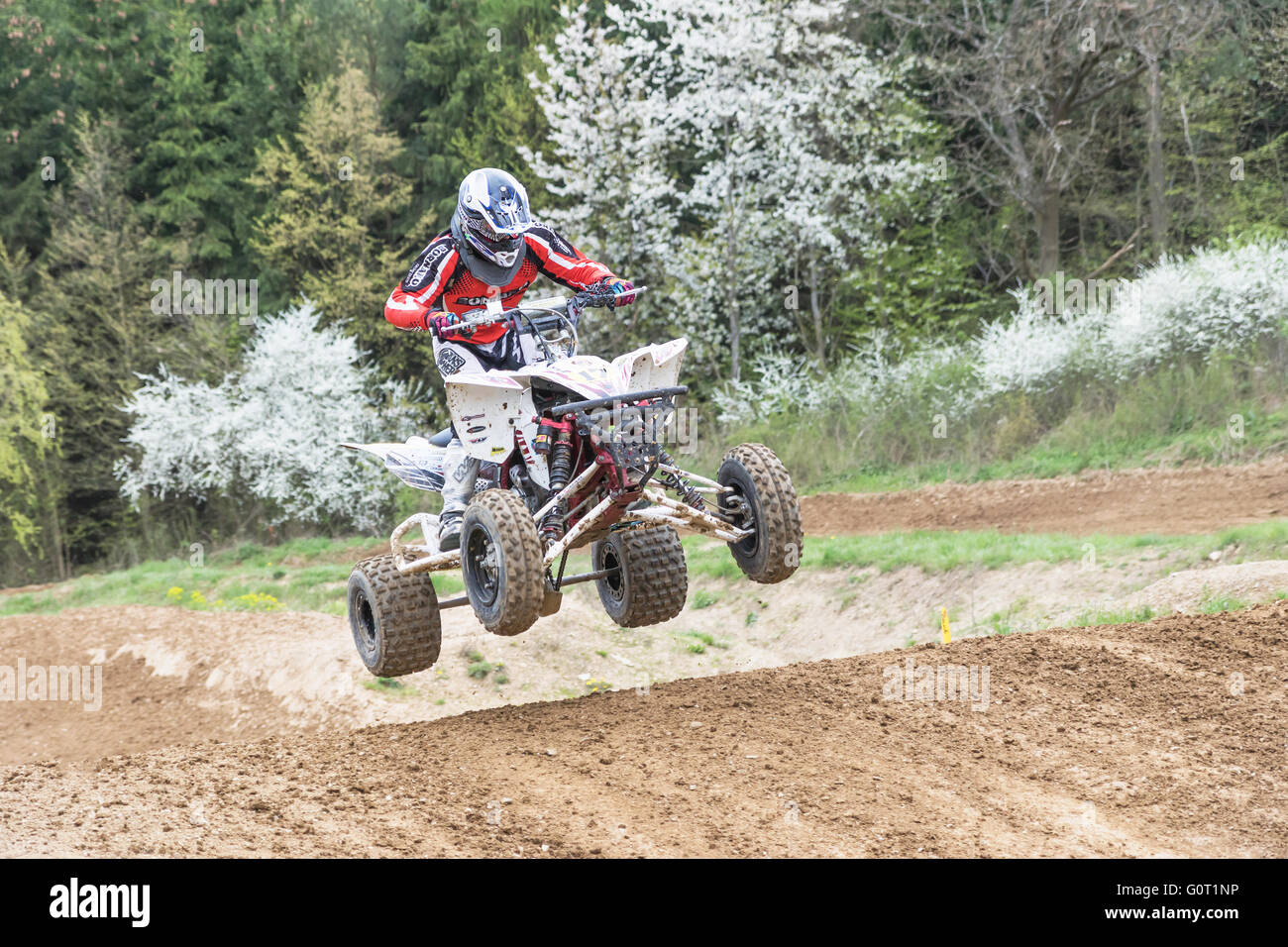 Quad rider in red is jumping in the terrain Stock Photo - Alamy