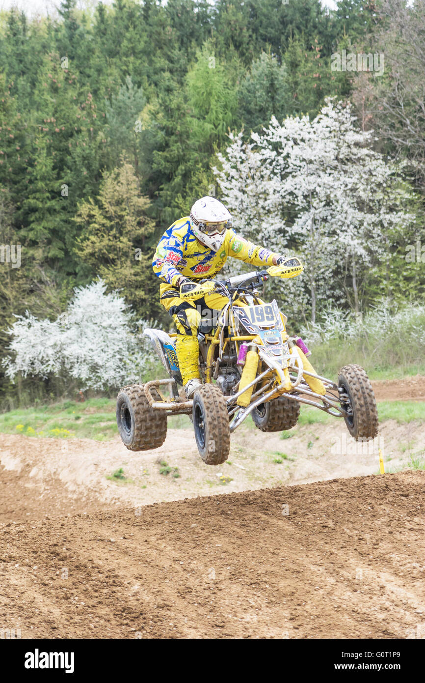 Quad rider in yellow is jumping in the spring nature Stock Photo - Alamy