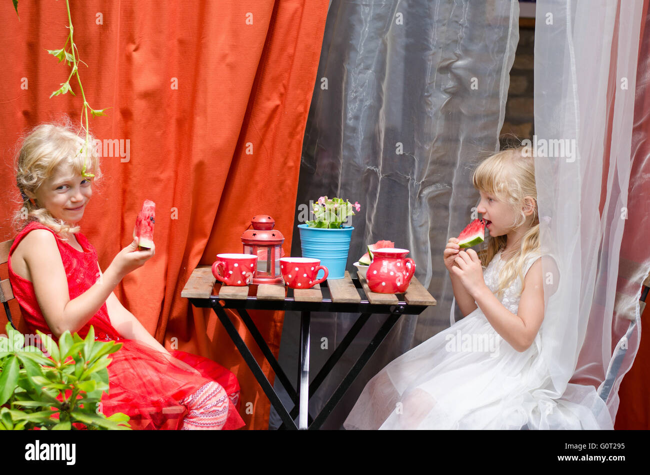 lovely blond girl sitting, drinking tea and eating water-melon Stock ...