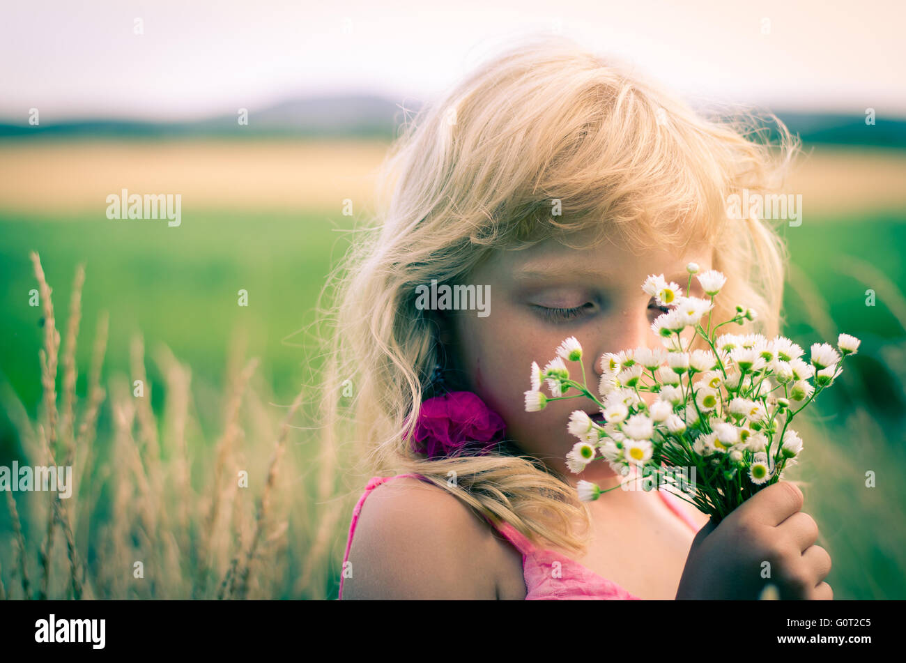little kid in the meadow holding bunch of spring flowers Stock Photo ...