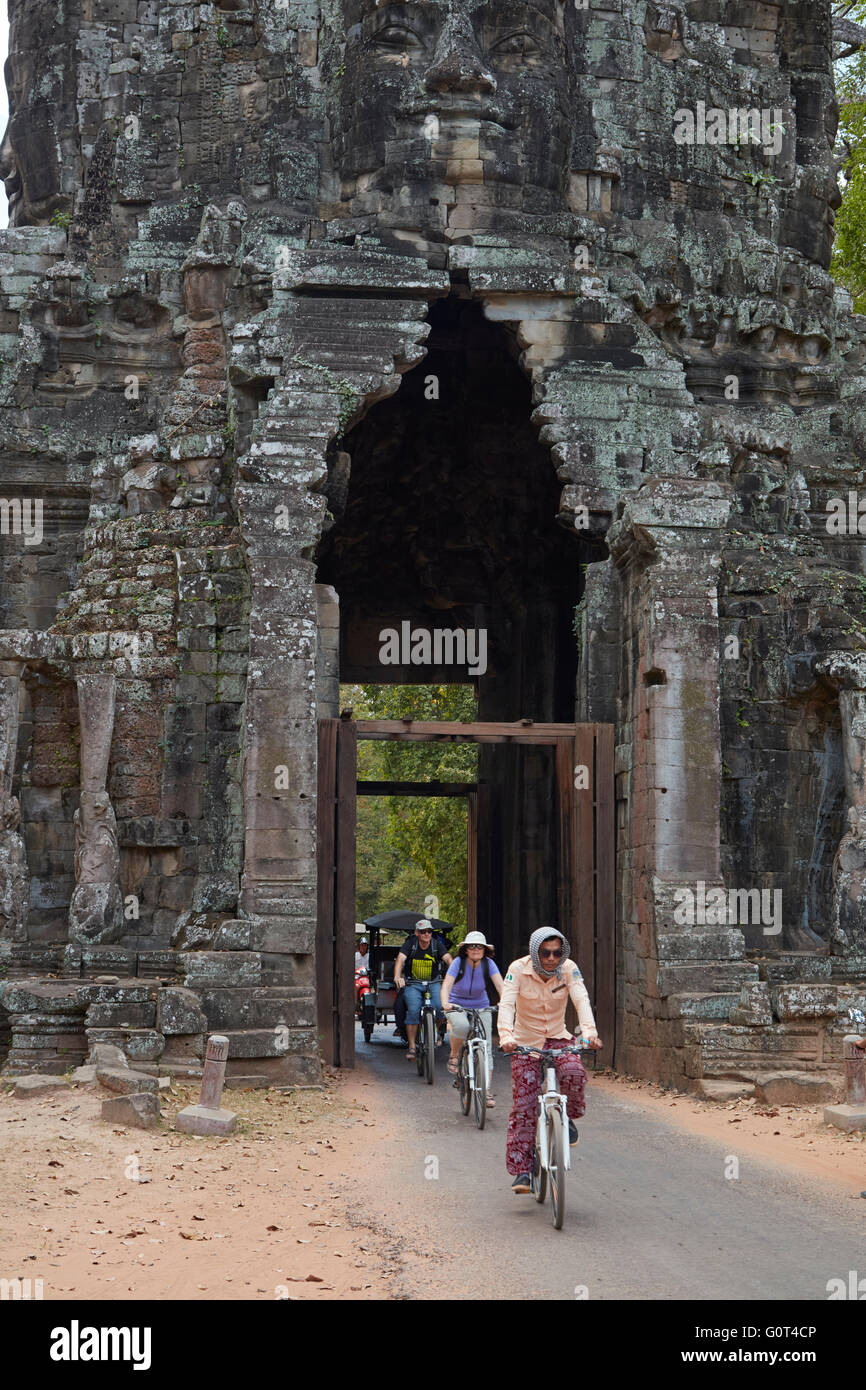 Cyclists going through Victory Gate, Angkor Thom (12th century temple ...