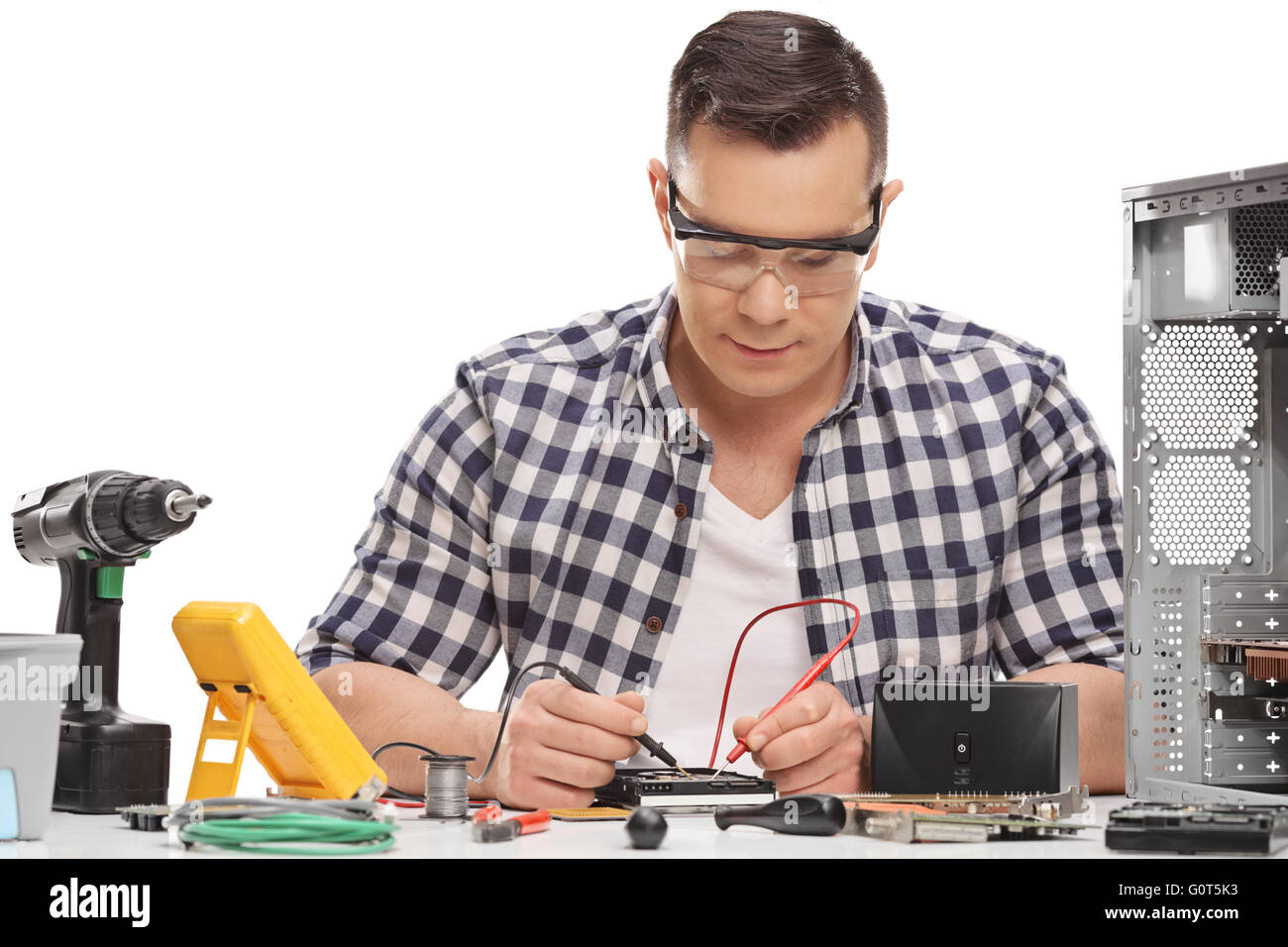 Male PC technician repairing a desktop computer and measuring ...