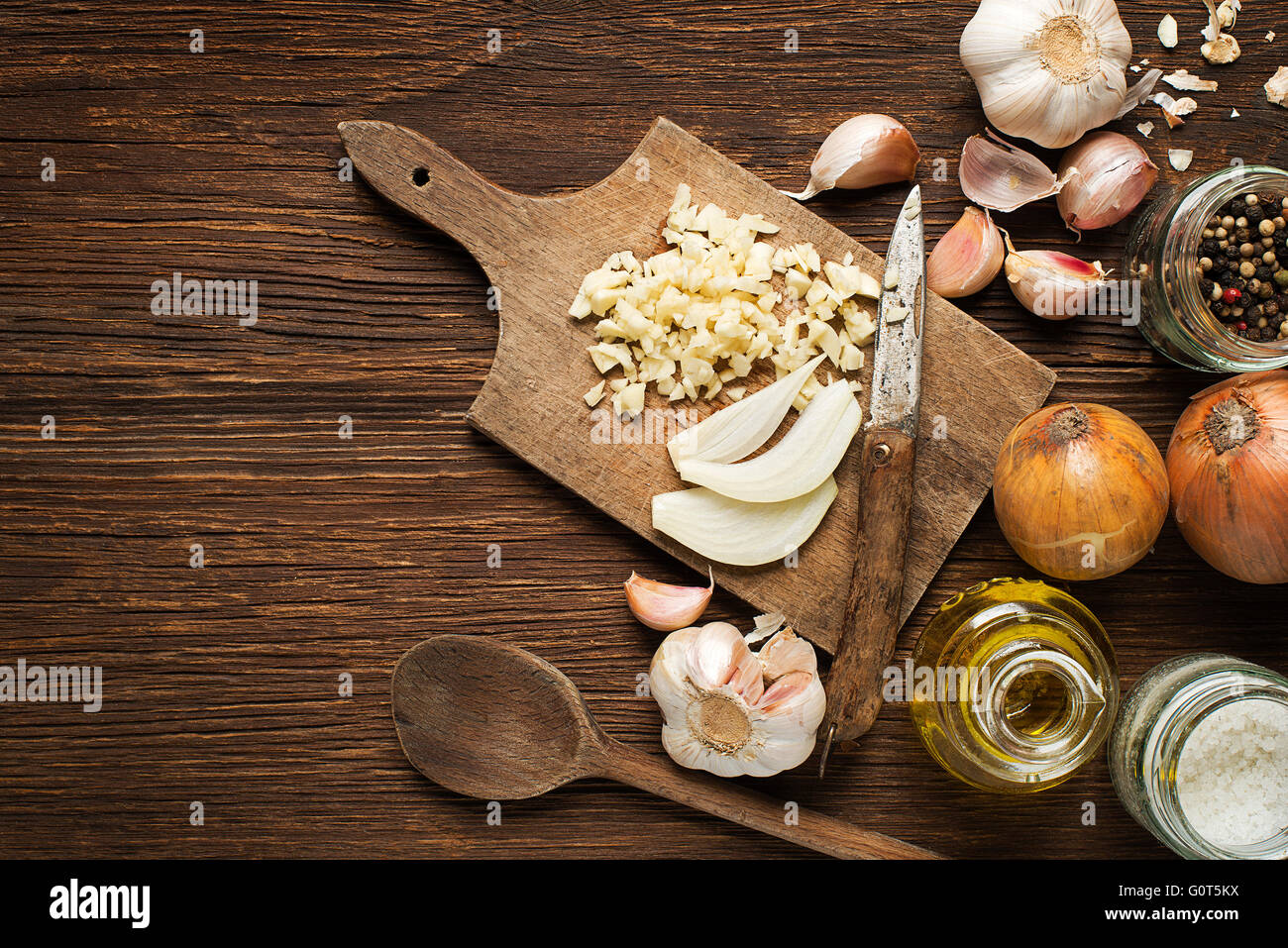 Ingredients with garlic cloves, onion and spices on wooden background ...