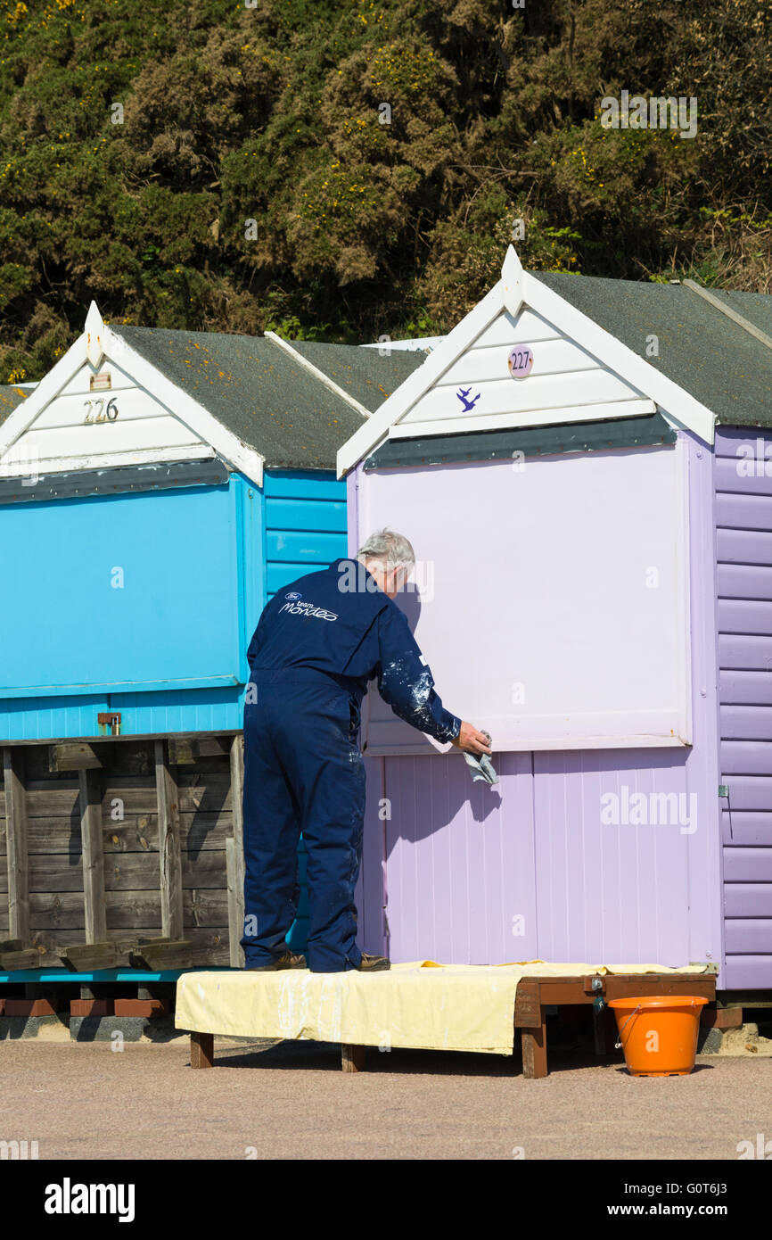 Man painting beach hut at Middle Chine along promenade at Bournemouth ...