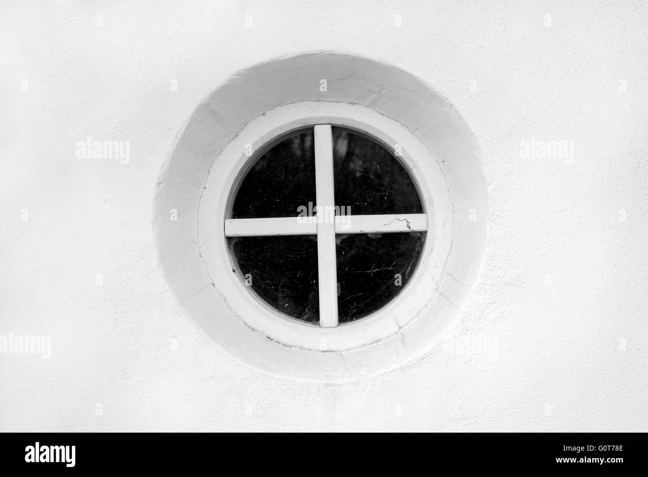 old round window on the white wall of the bell tower of the Orthodox ...