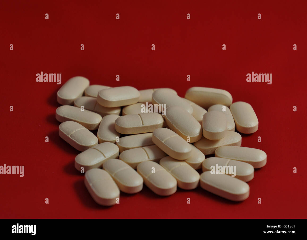 Medical pills for treatment on a red background Stock Photo - Alamy