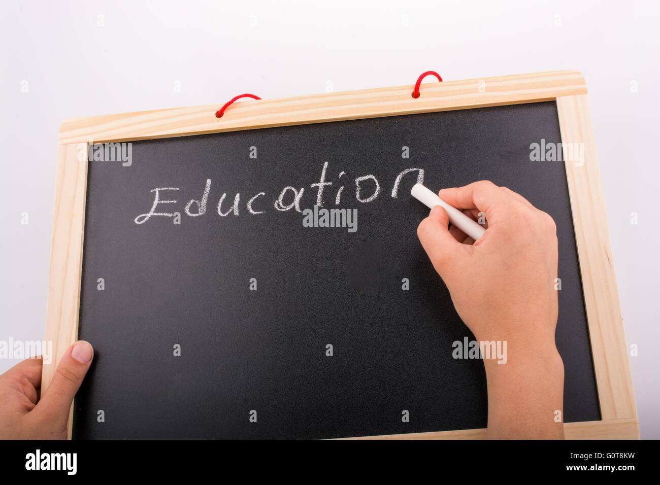 Hand holding a blackboard with 'education' written on it on a white ...