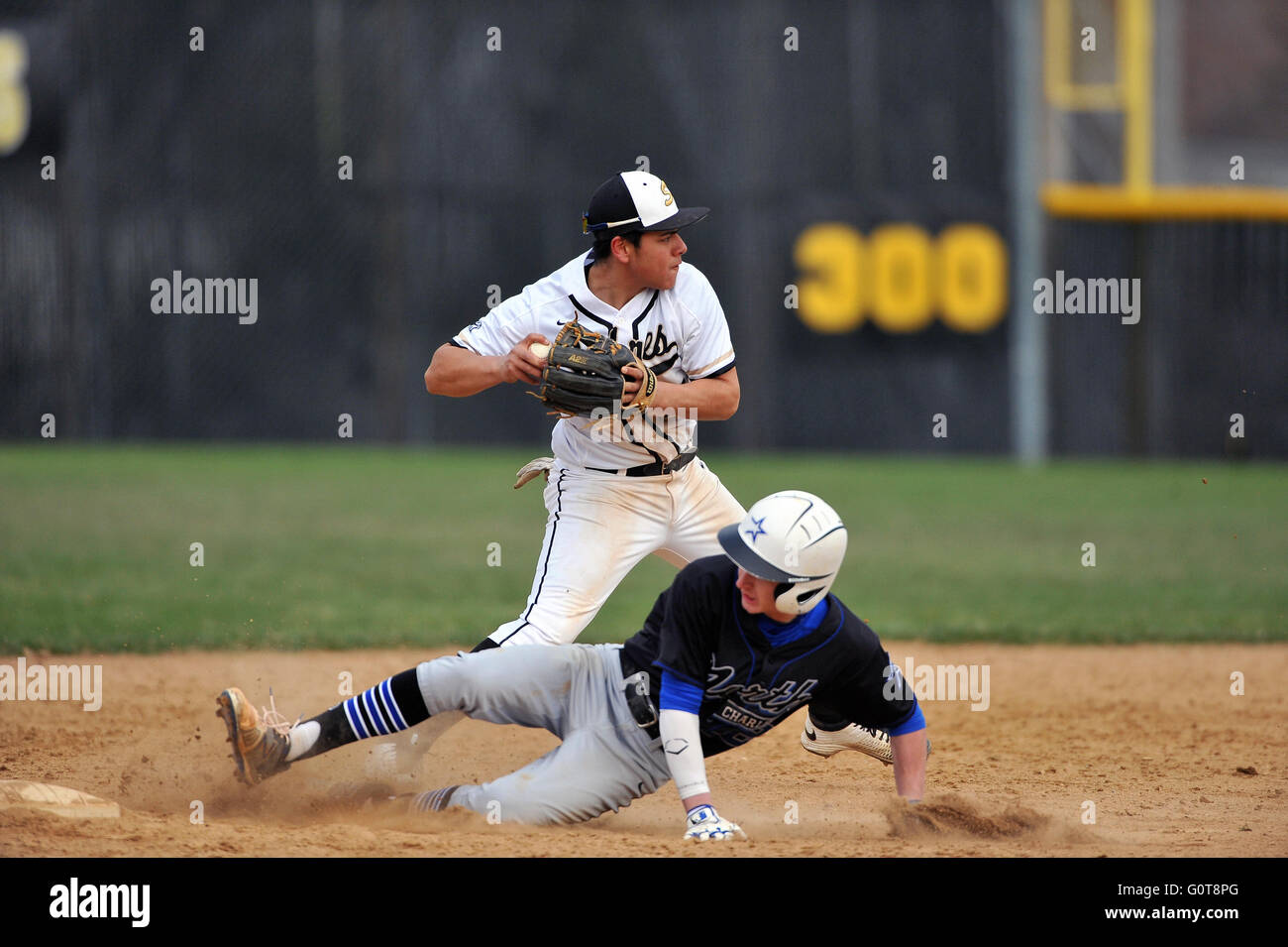 High school player sliding in hard to second base in an effort to ...