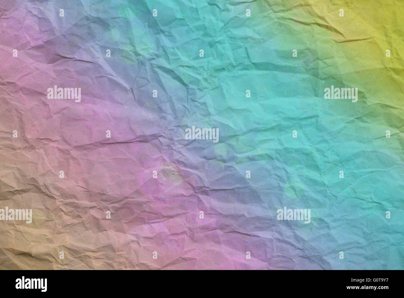 Closeup of a section of crumpled wrapping paper overlaid with colors ...