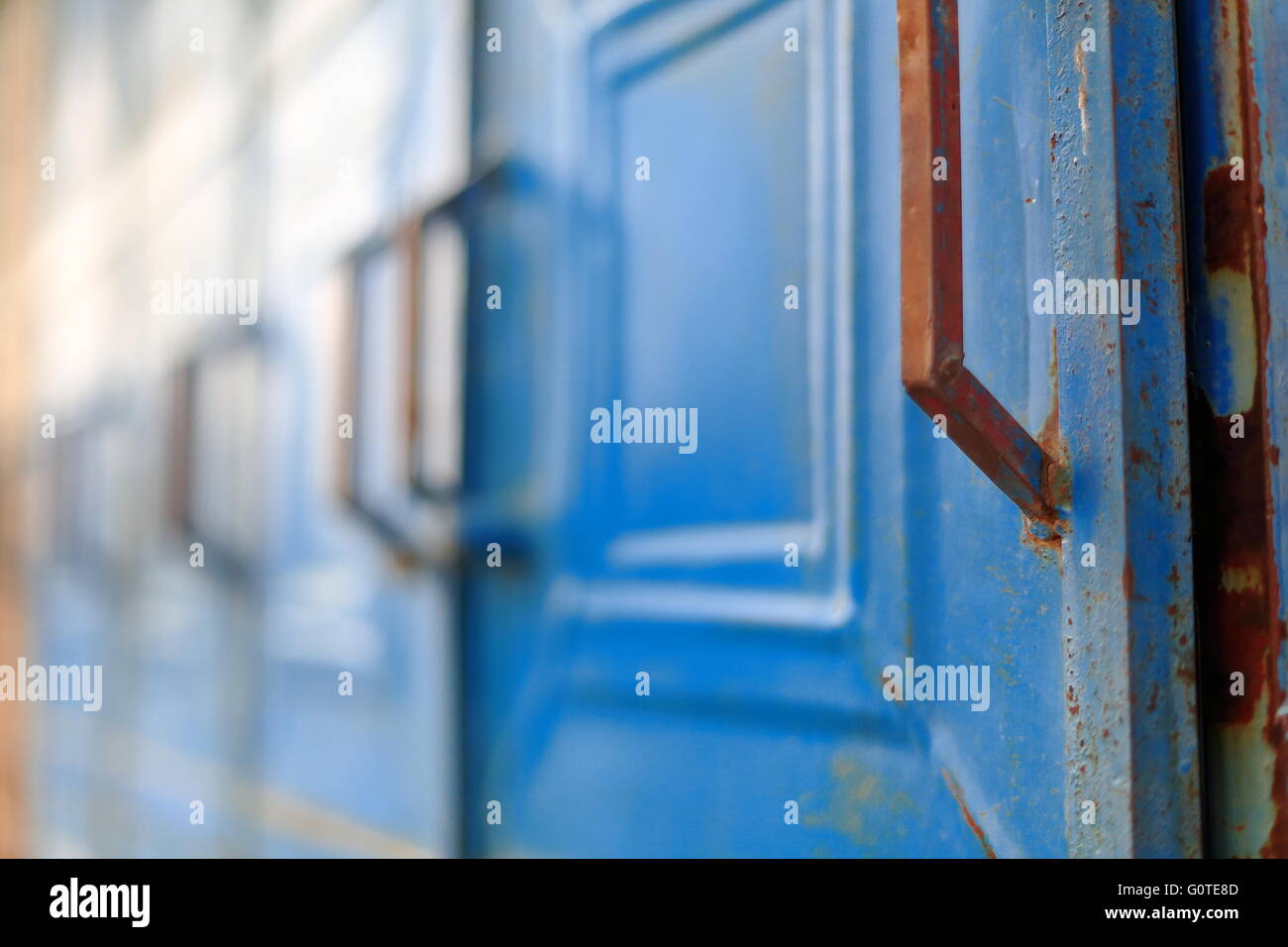 Blue painted metallic doors of closed stores. Commercial building on a ...