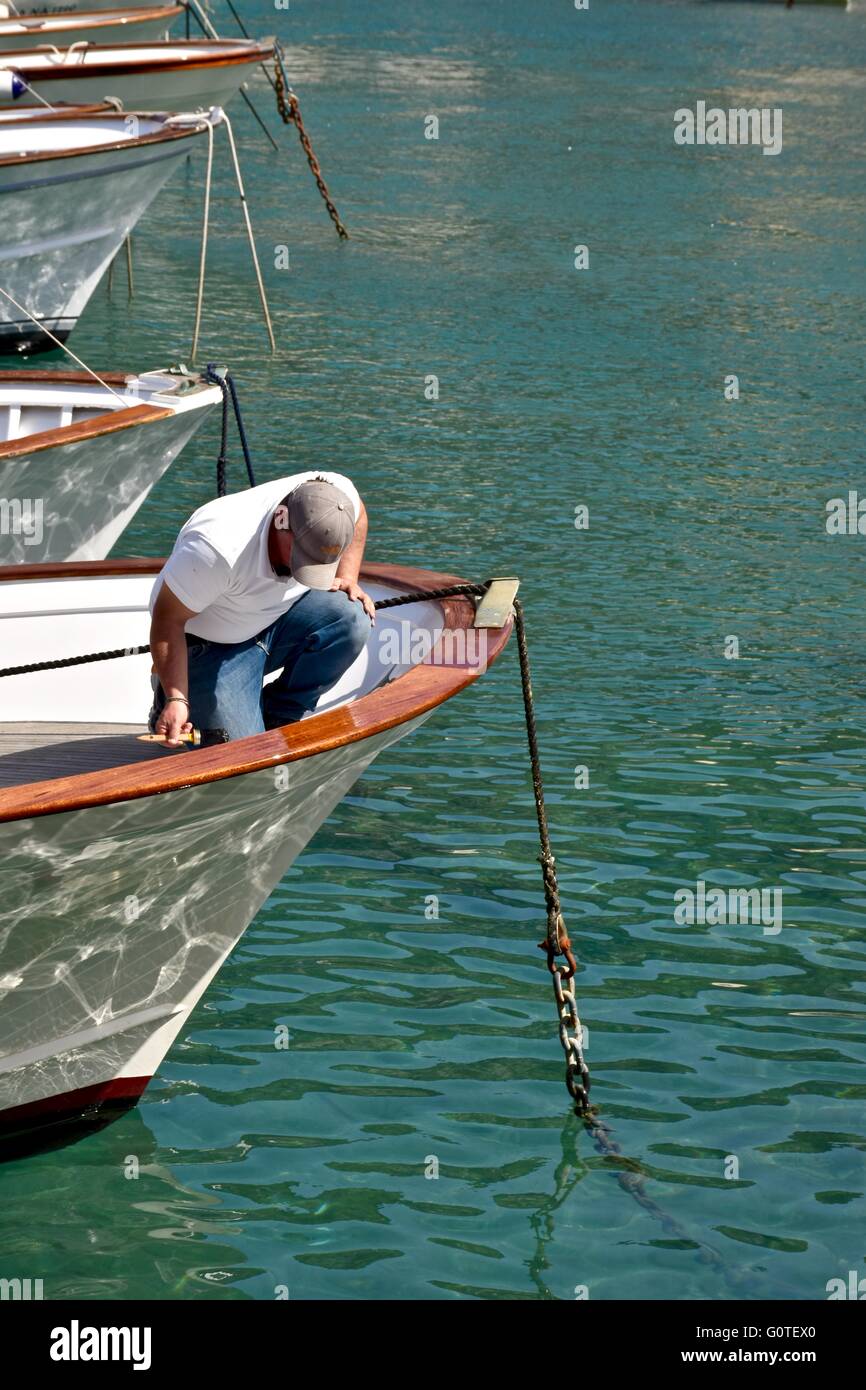 Man on the front of his boat ready to pull the anchor Stock Photo - Alamy