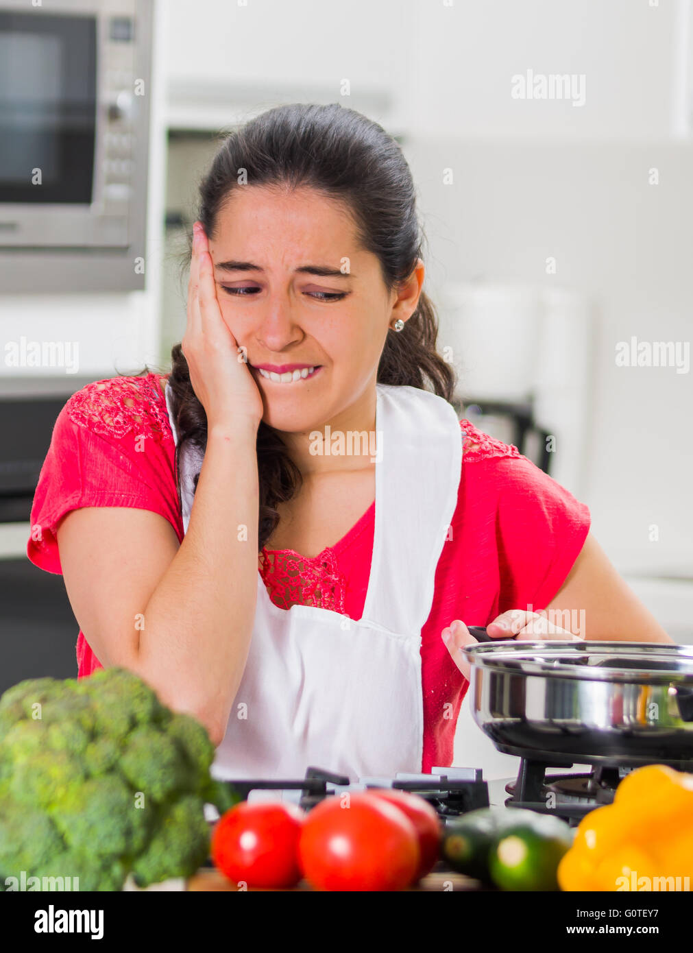 Young woman chef cooking with skeptical facial expressions, interacting ...