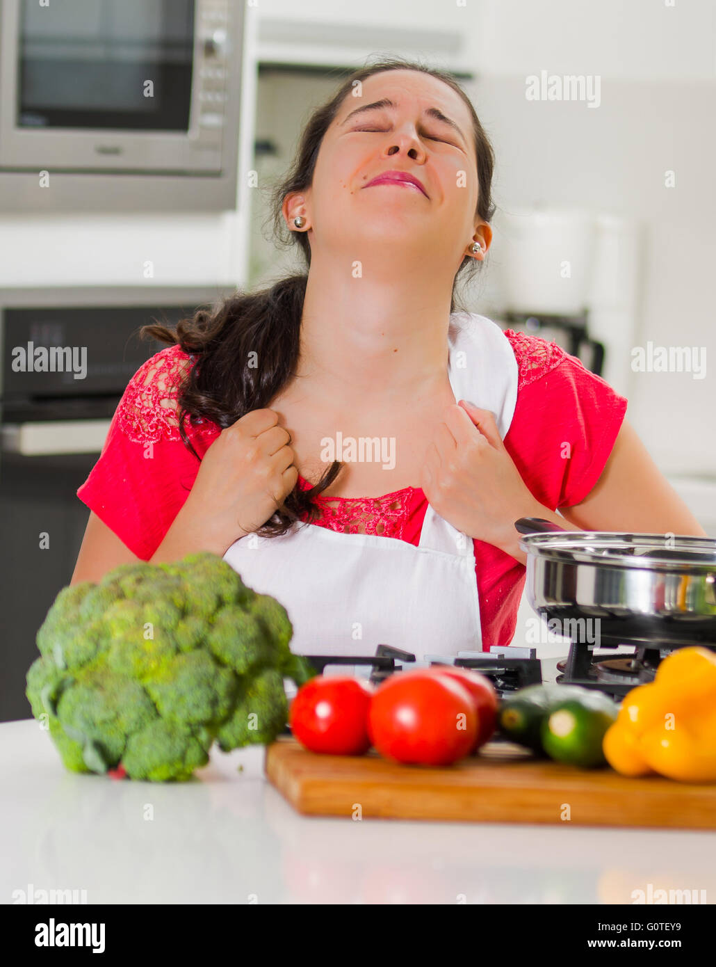Young woman chef cooking with skeptical facial expressions, interacting ...