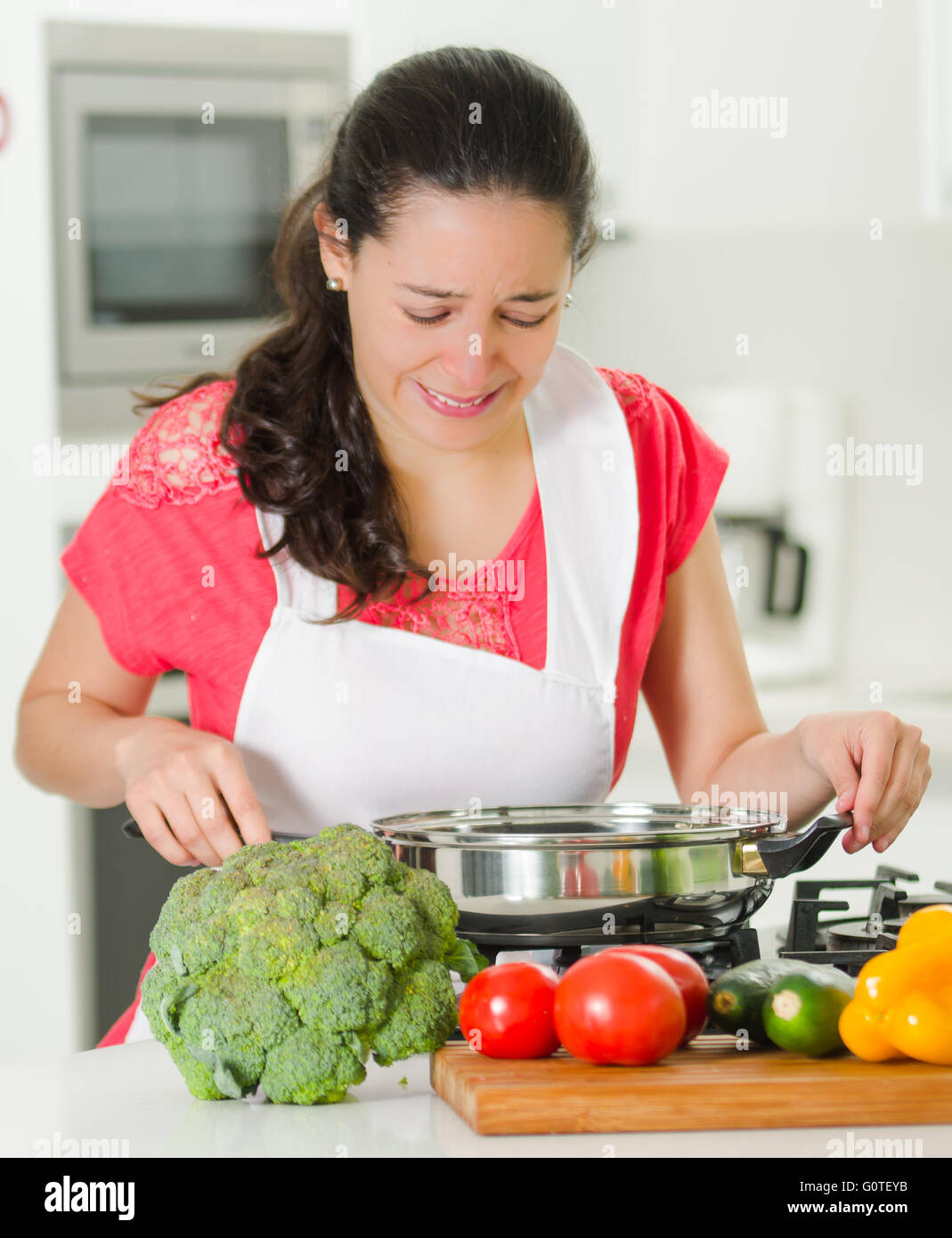 Young woman chef cooking with skeptical facial expressions, interacting ...
