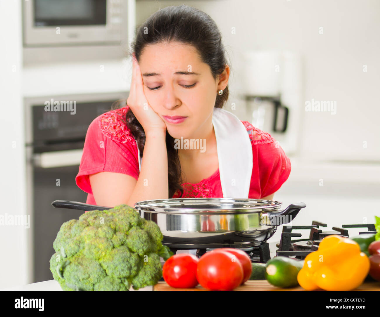 Young woman chef cooking with skeptical facial expressions, interacting ...
