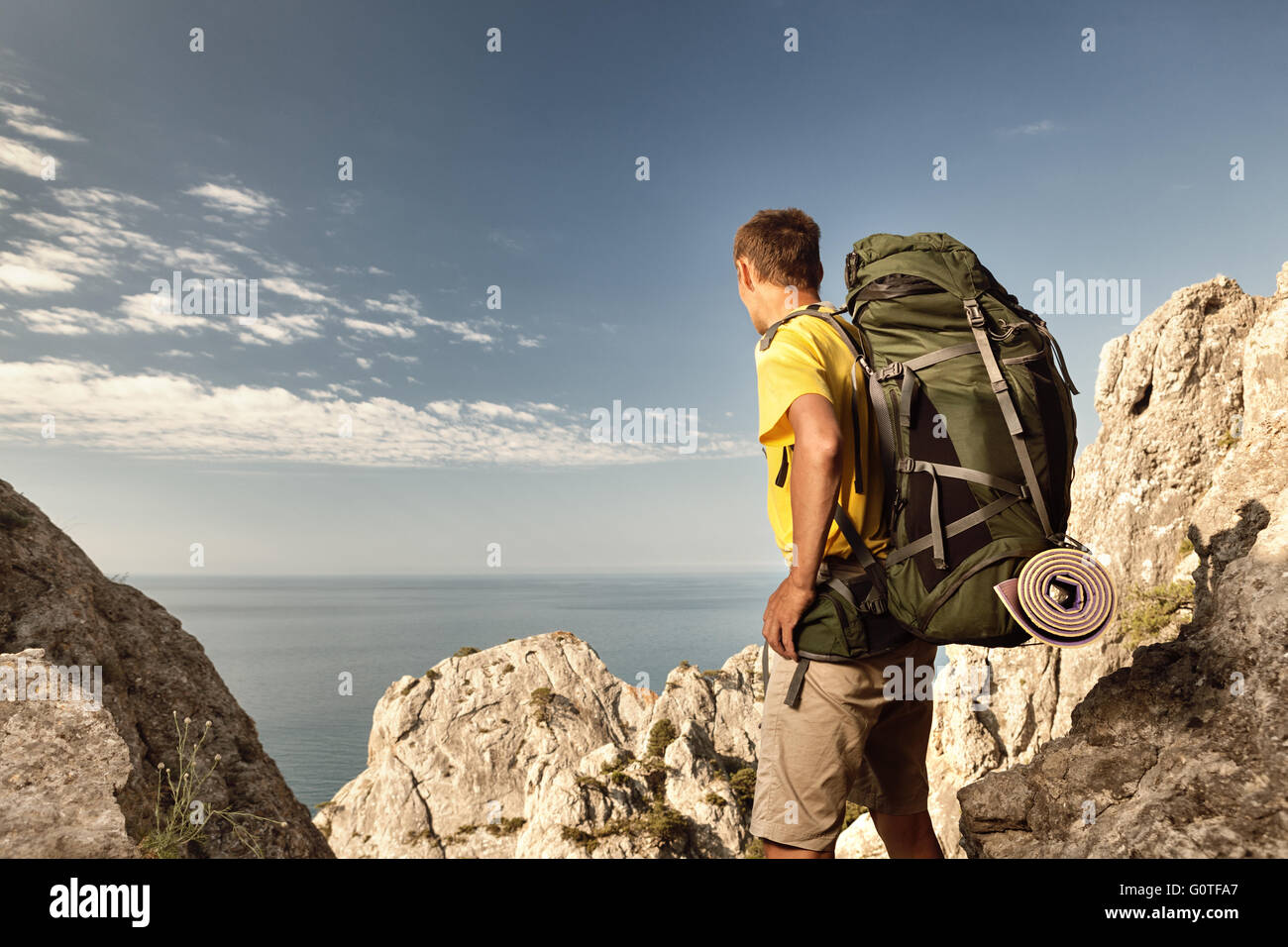 Backpacker on high rock Stock Photo - Alamy