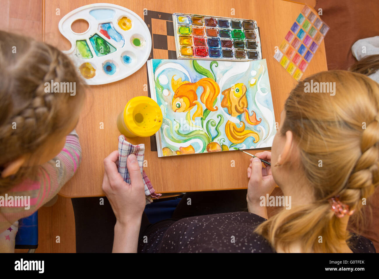 Teaching a child watercolor drawing top view Stock Photo - Alamy