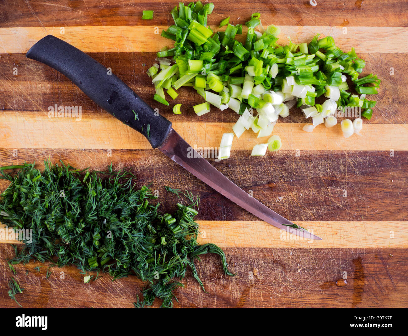 Dill and spring onions on chopping board with knife Stock Photo - Alamy