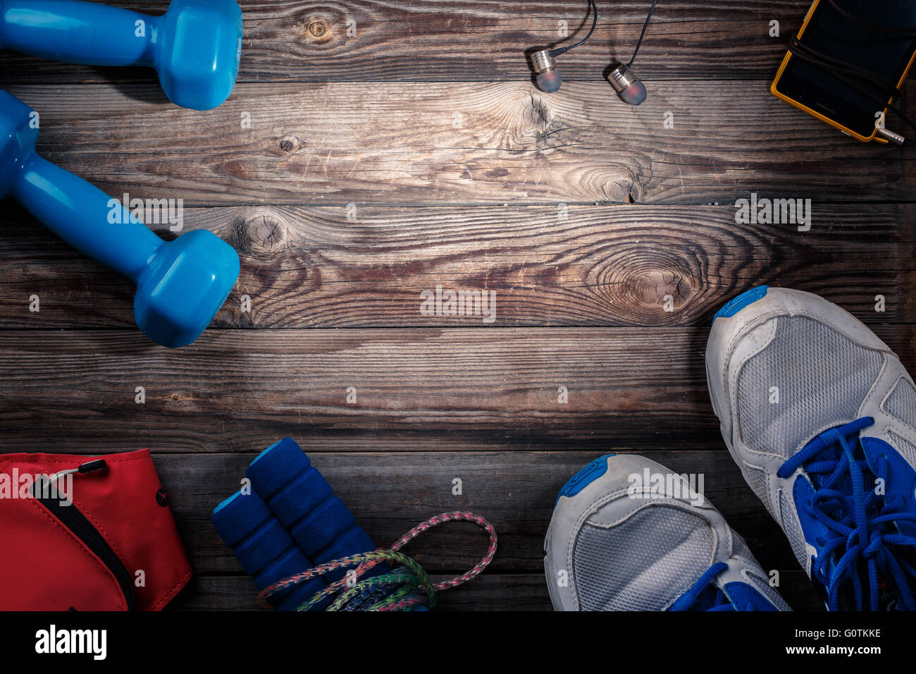Sport stuff on wooden table, top view. Light spot in center of wooden ...