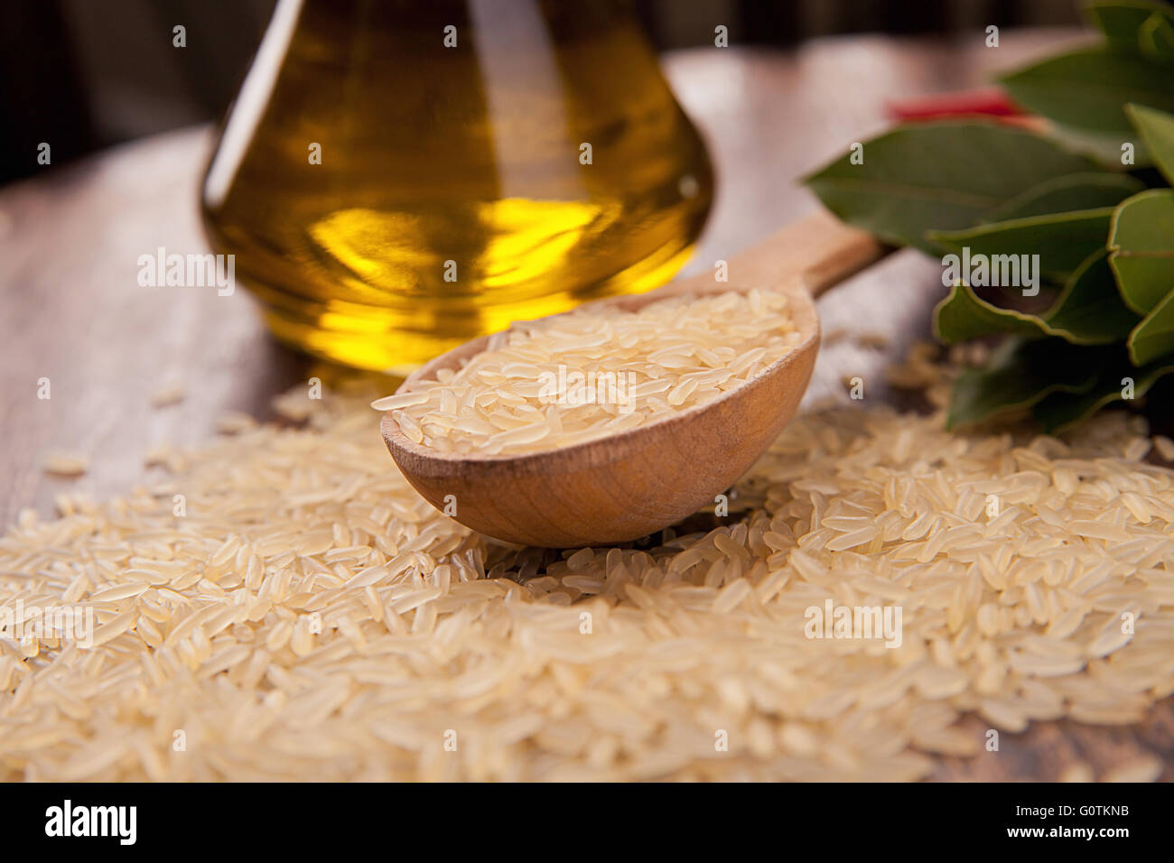 uncooked rice with spoon and woody background Stock Photo - Alamy