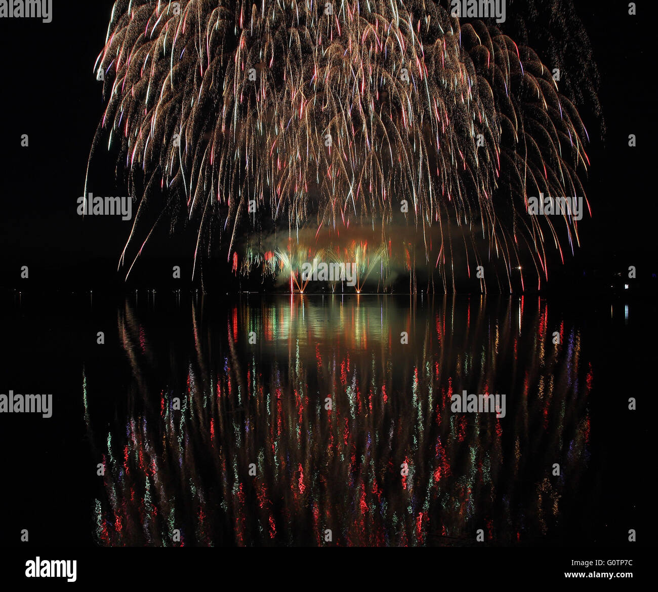 Colorful fireworks with reflection on lake and night sky in background ...