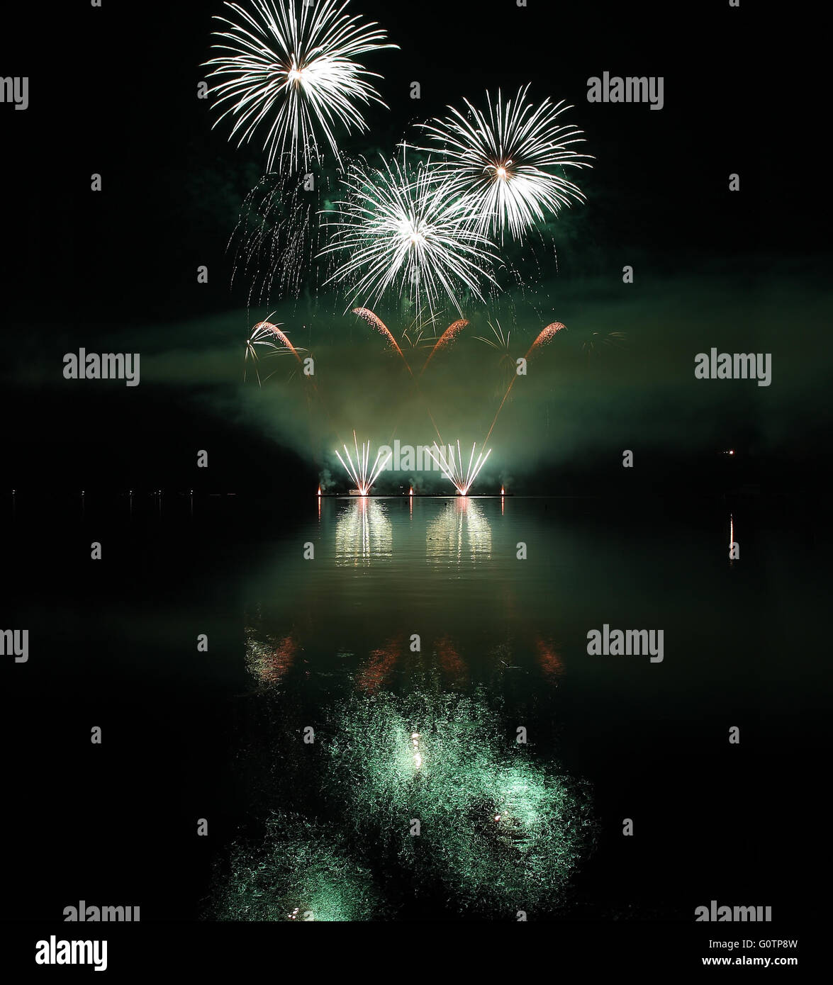 Colorful fireworks with reflection on lake and night sky in background ...