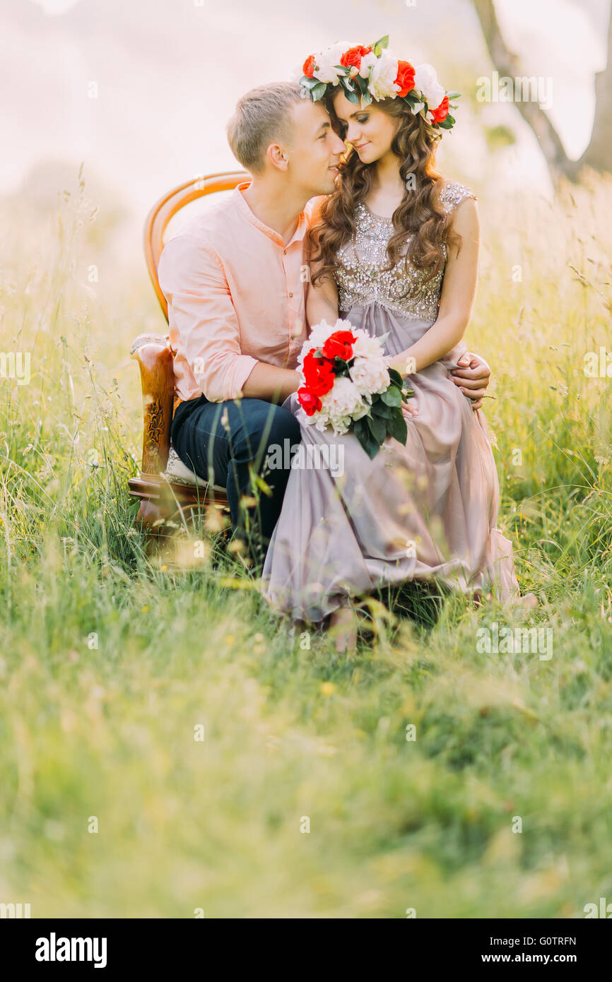 Close-up photo of beautiful smiling young couple sitting in the chair ...