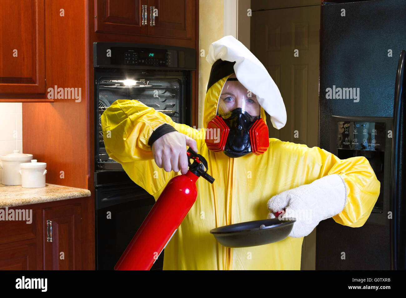 Woman in HazMat suit and respirator wearing chef's hat holding fire ...