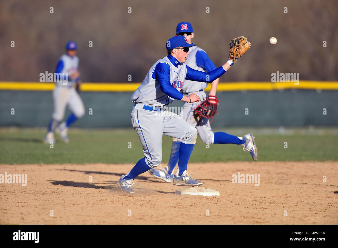High school shortstop at second base accepting a throw before making a ...