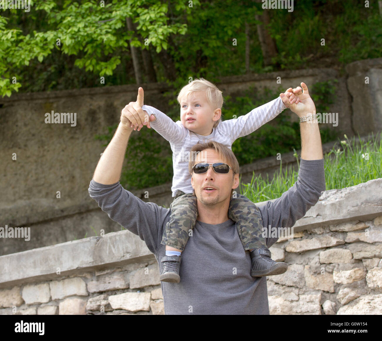 Blond boy sitting on fathers shoulder outdoors Stock Photo - Alamy