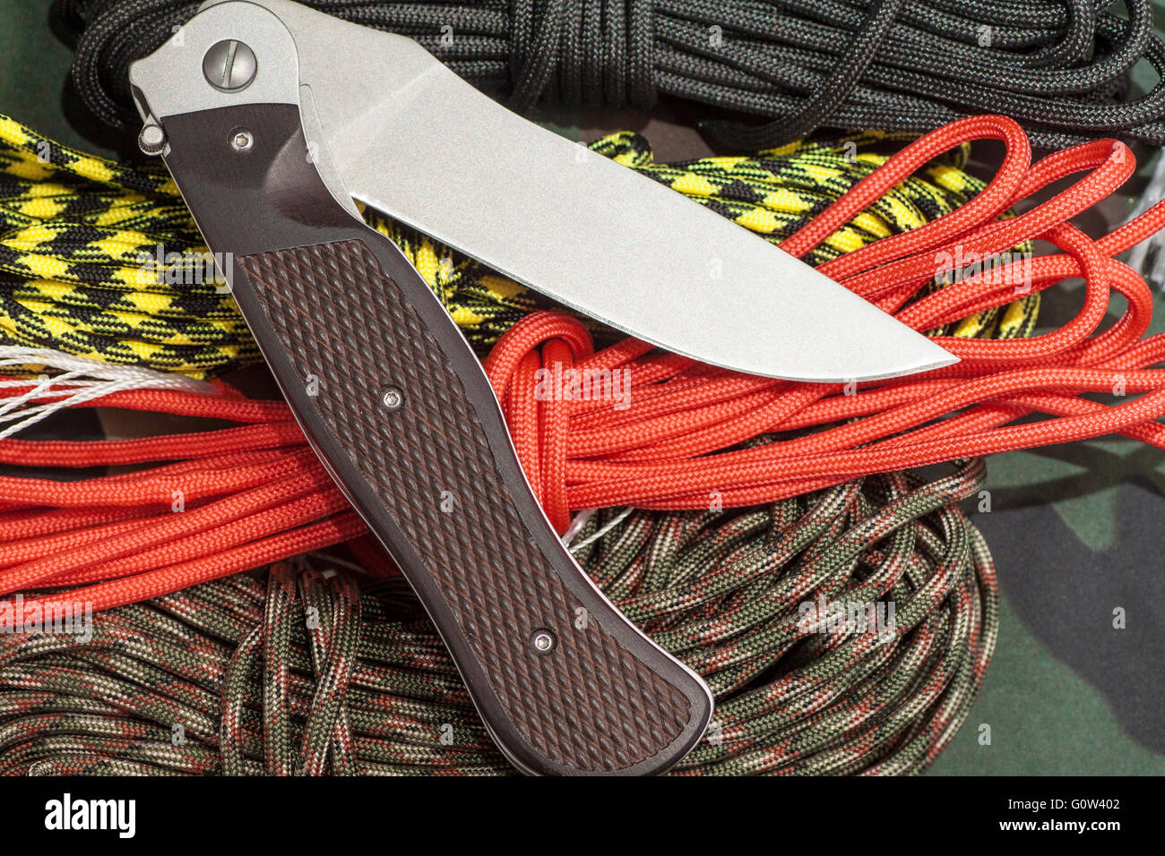 tactical folding knife with a rope on camouflage background Stock Photo ...