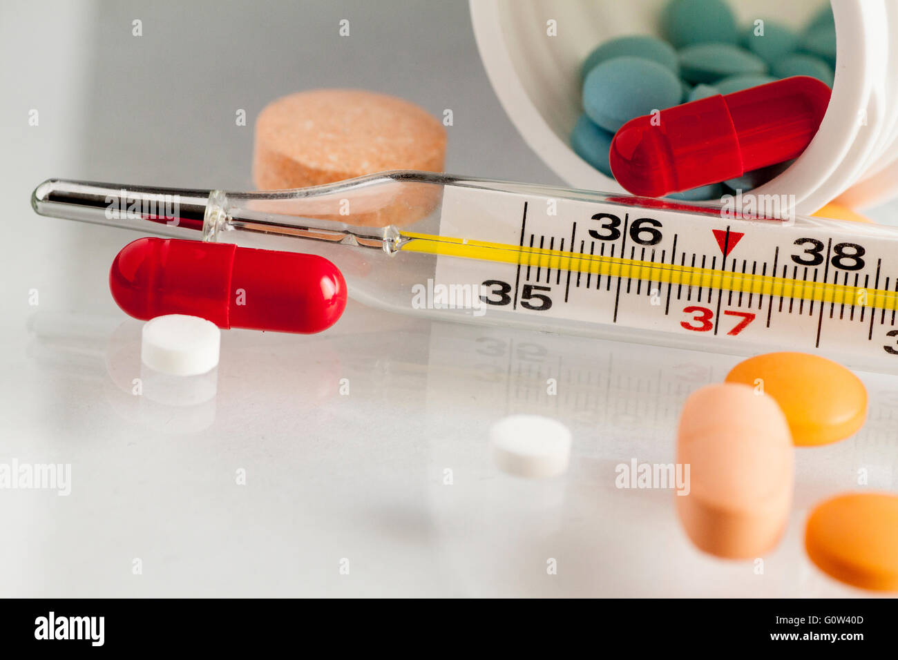 Thermometer with pills and capsules isolated on white background Stock ...