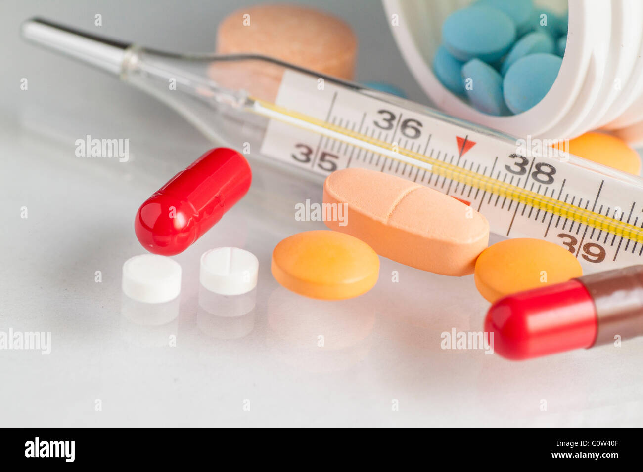 Thermometer with pills and capsules isolated on white background Stock ...