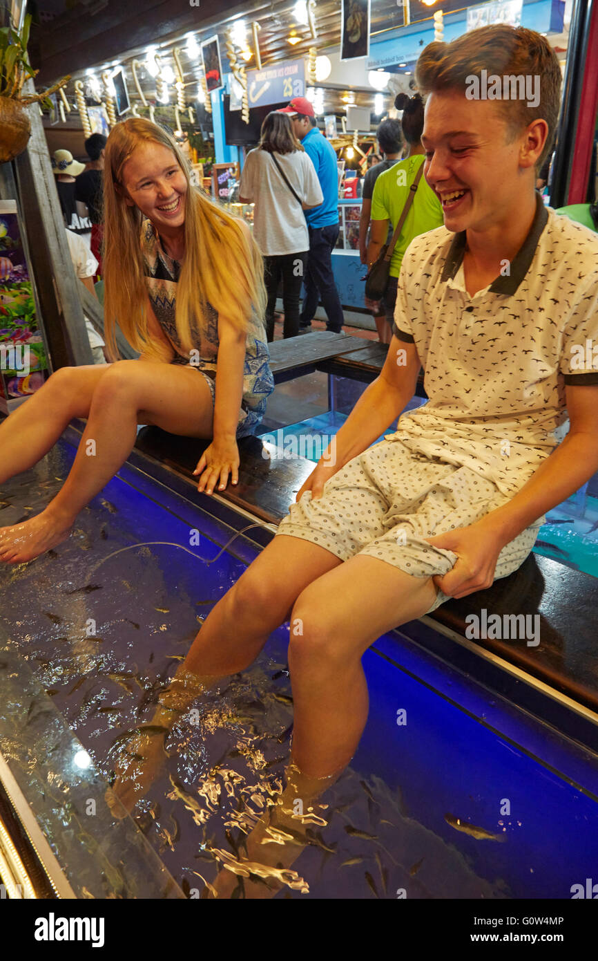 Fish tickling young tourists as they eat dead skin off feet, Siem Reap ...