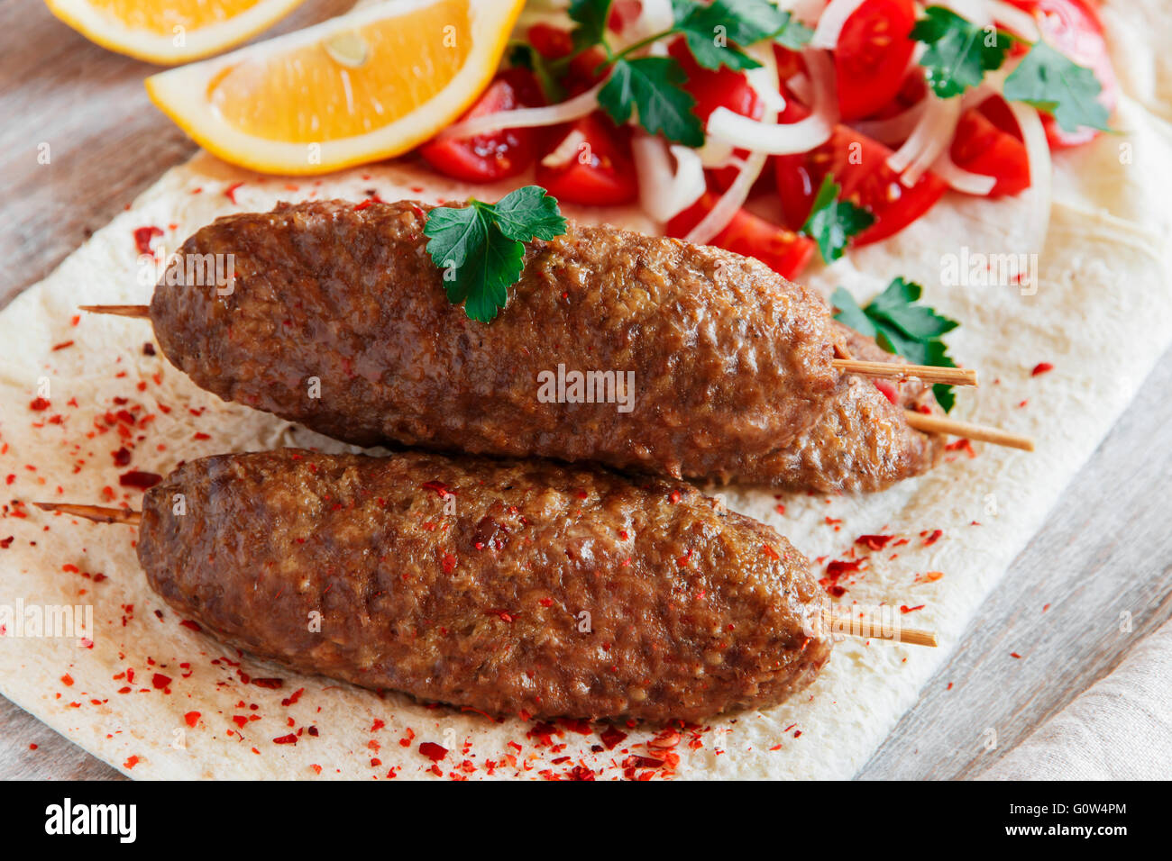 Grilled kebab meat on wooden skewers with vegetables Stock Photo - Alamy