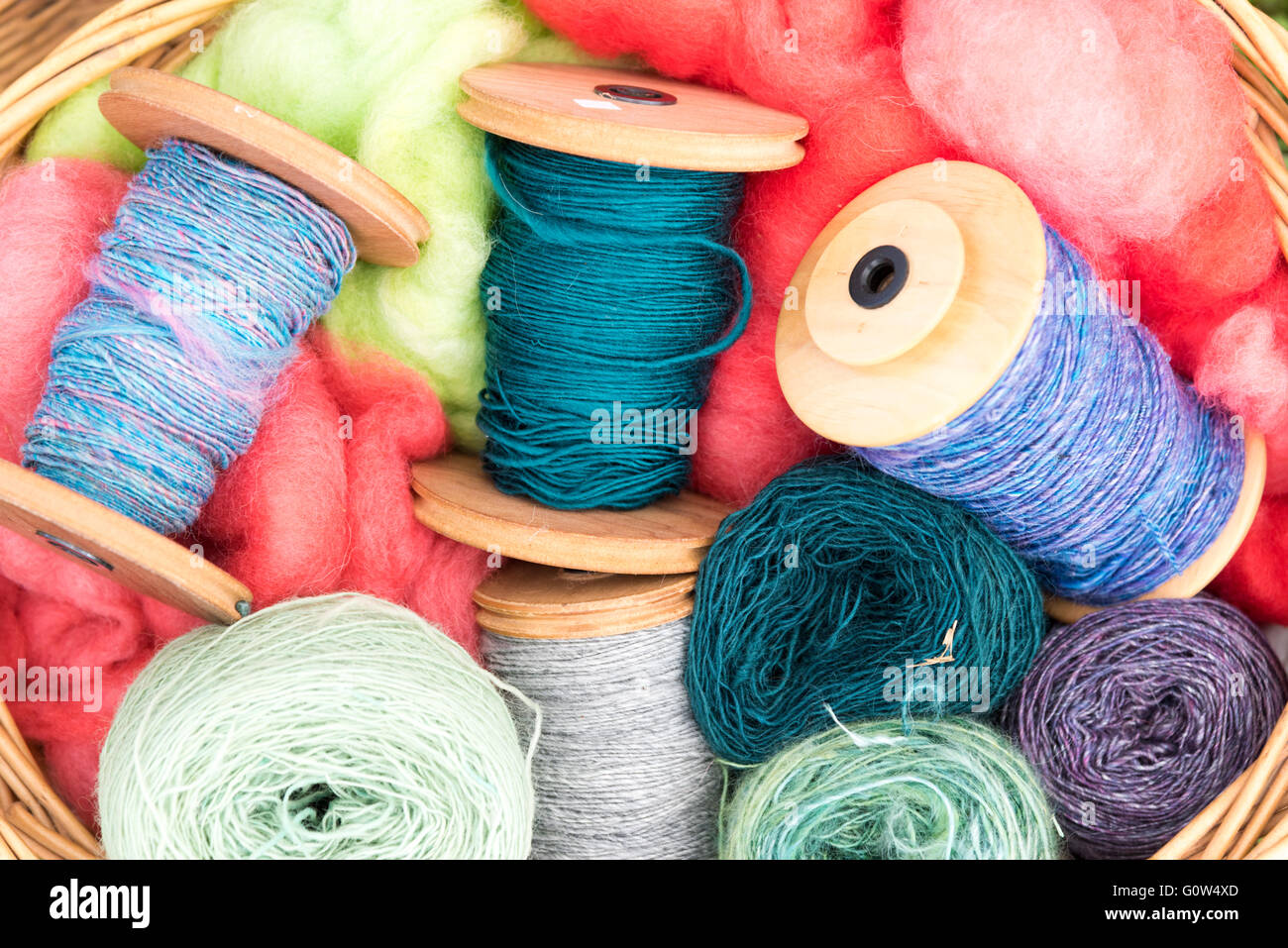 Brightly coloured wool on bobbins in a basket Stock Photo - Alamy