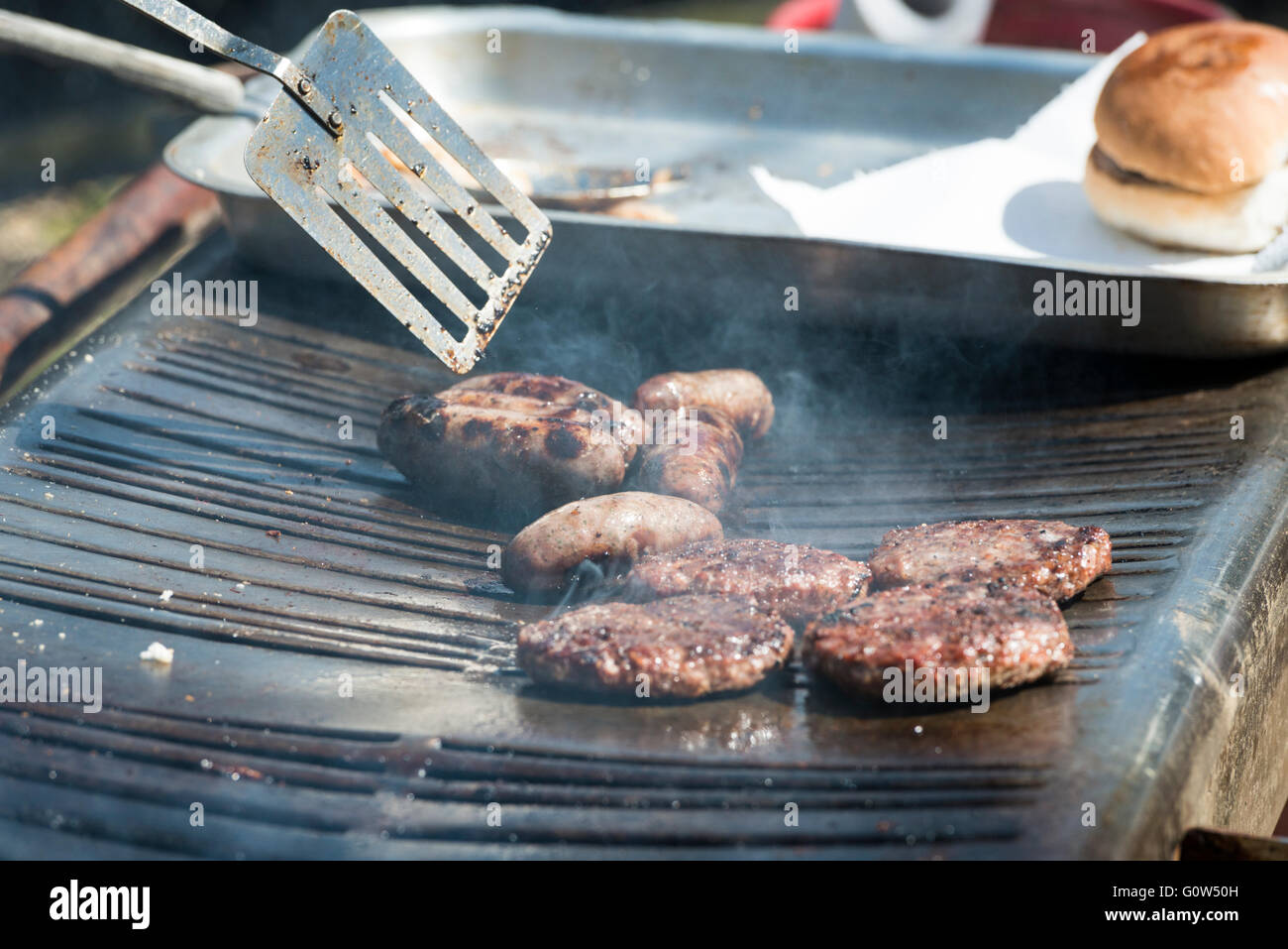 Burgers and sausages being cooked on a barbeque Stock Photo - Alamy