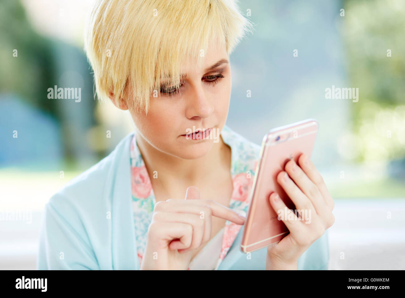 Girl reading message on her iPhone Stock Photo - Alamy