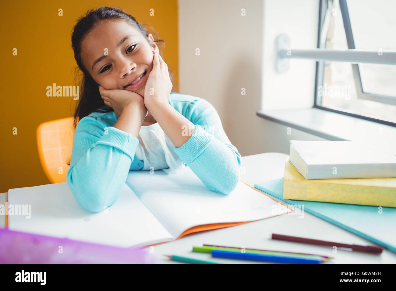 Girl sitting at a desk Stock Photo - Alamy